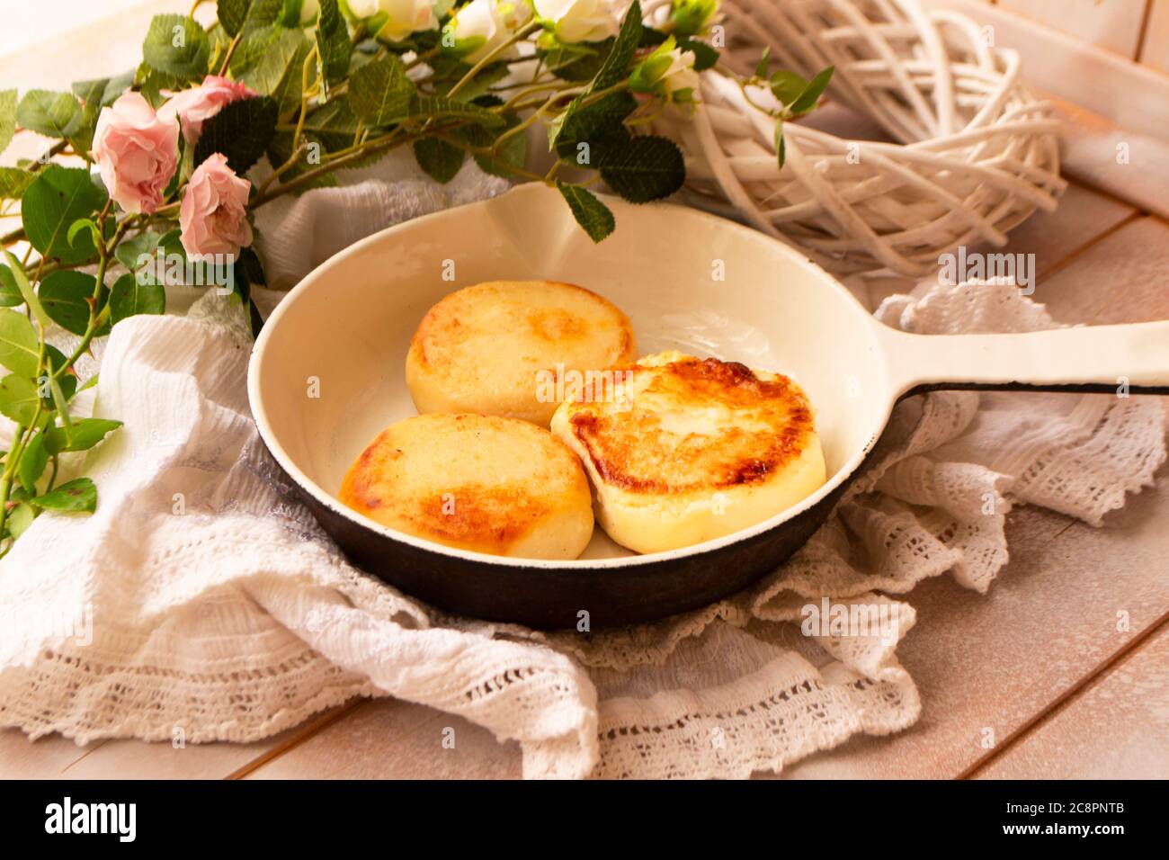 Baked fried cottage cheese pancakes in a white vintage pan, shabby ...