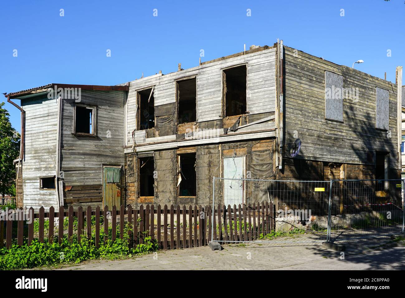 an old abandoned two-storey wooden house on a city street under ...