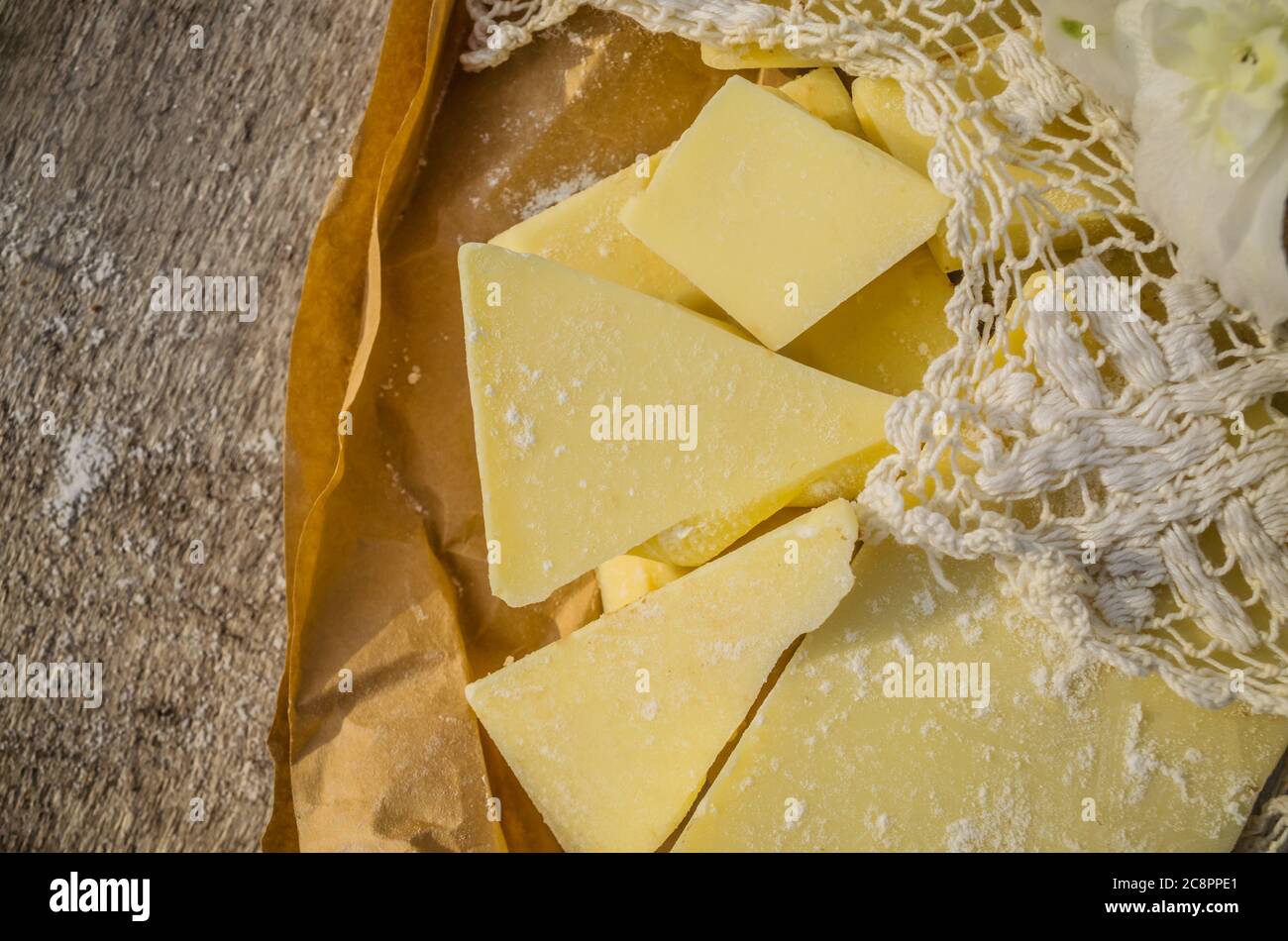 Pieces of cocoa butter with lace and white flowers. White chocolate on ...
