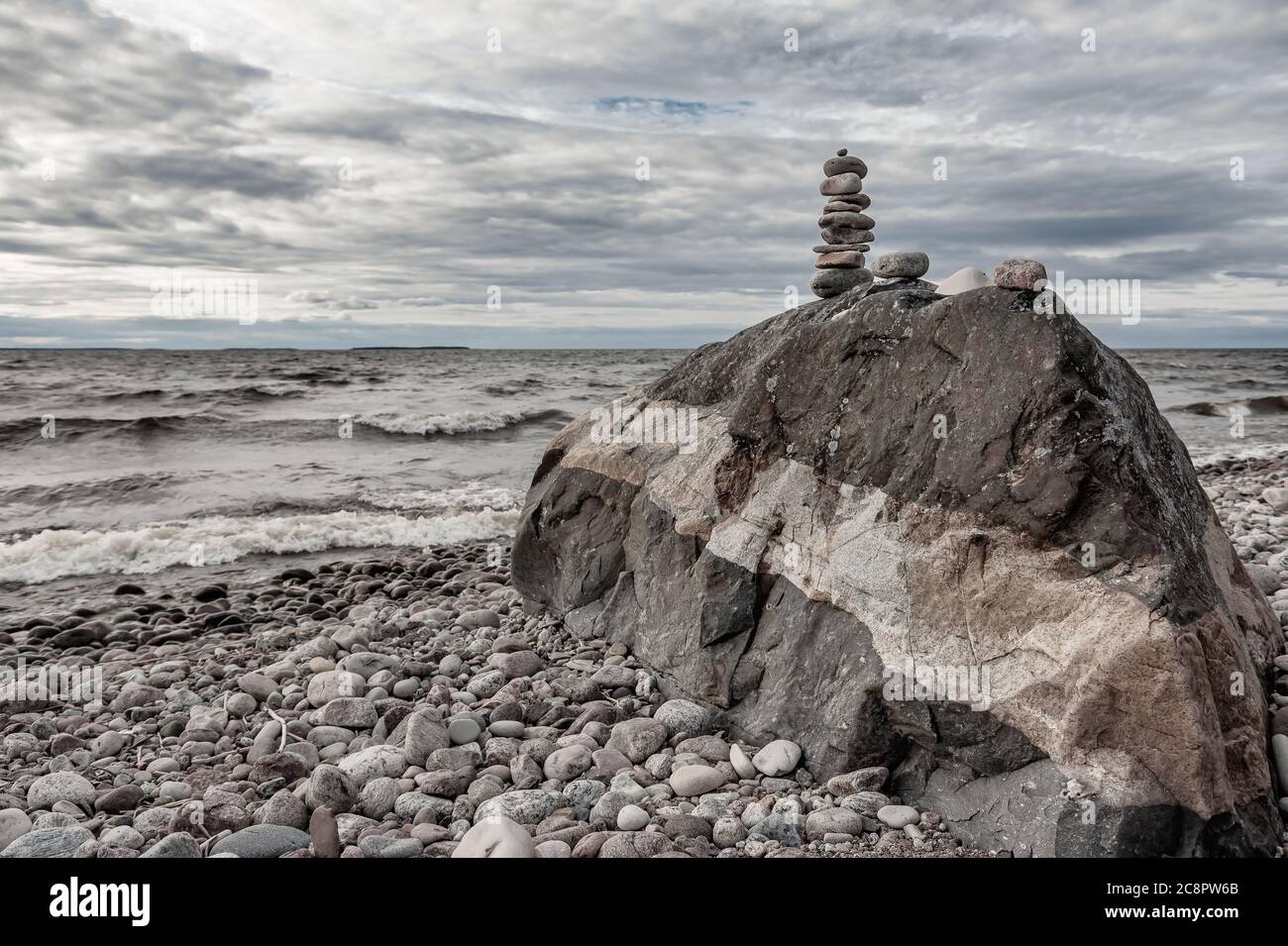 Beautiful natural stones that are stacked on a large rock by the ...