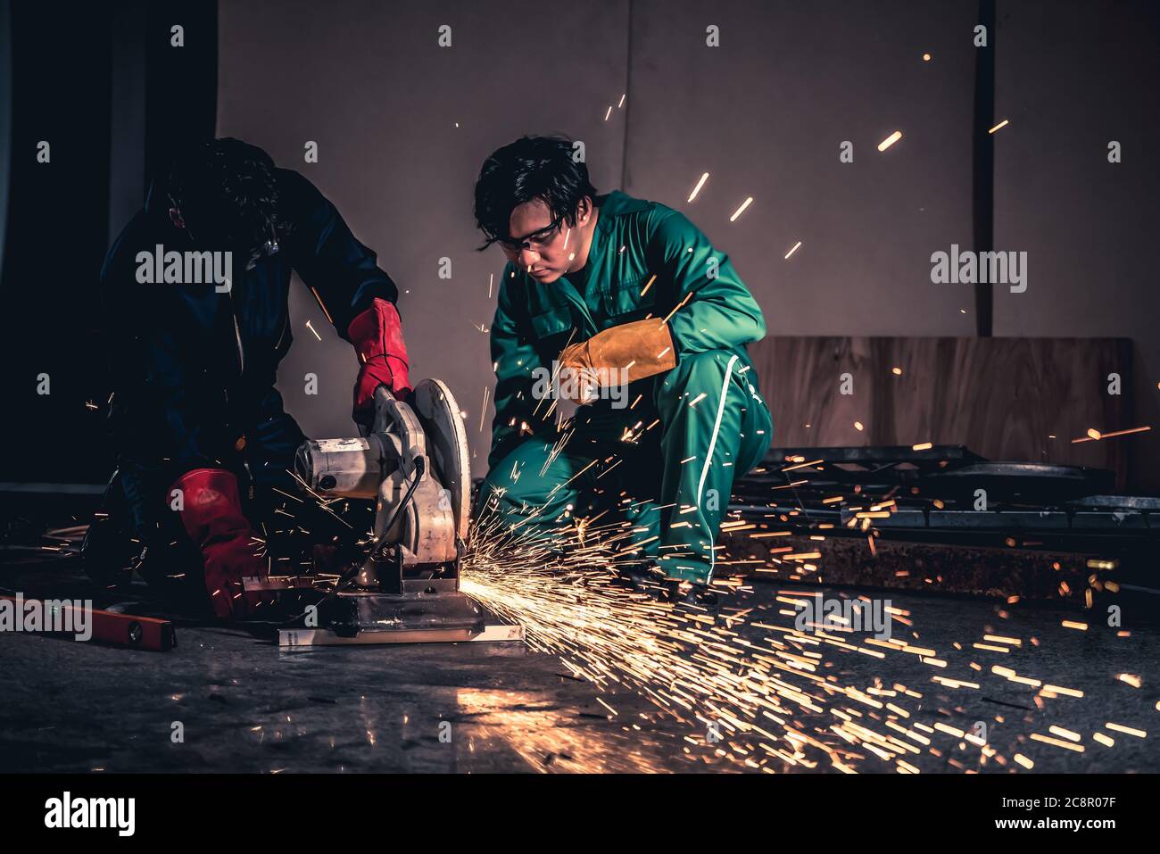 Professional mechanic man is cutting steel metal with rotating carbon ...