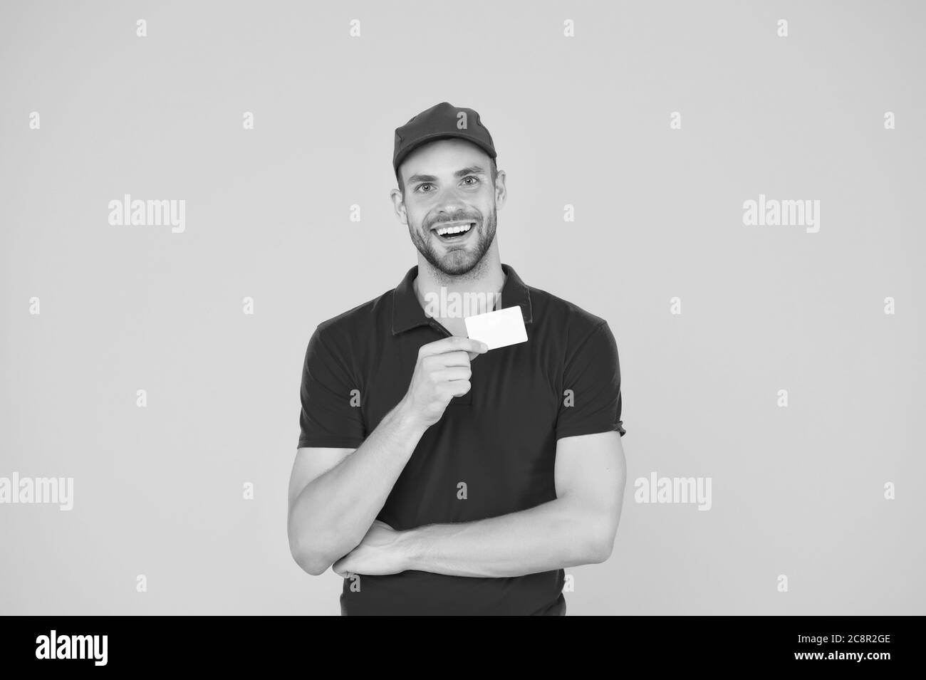 Happy to serve. Man red cap yellow background. Delivering purchase ...