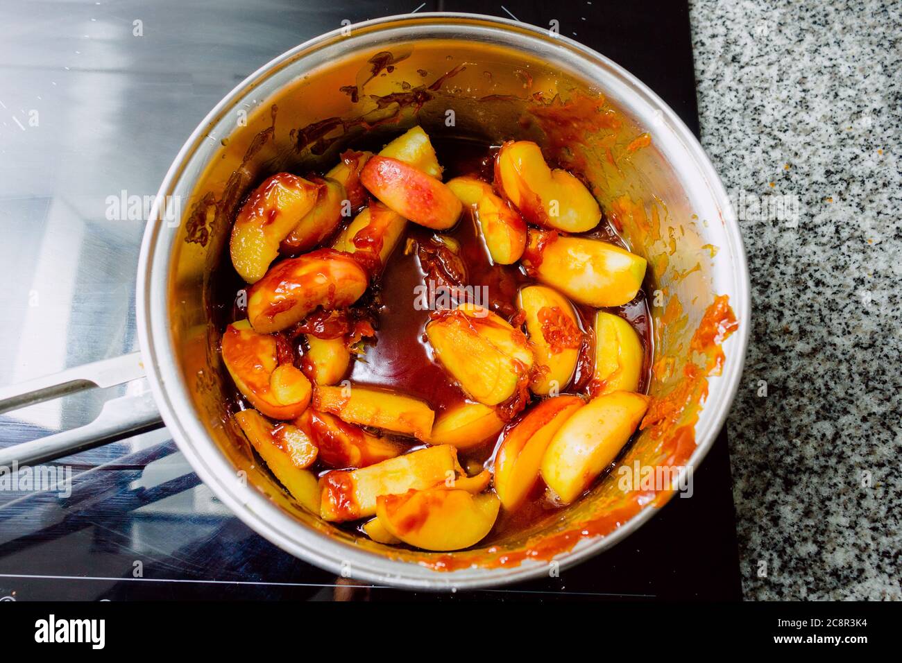 Aerial view of caramelized apples in a pot on an induction cooker ready ...