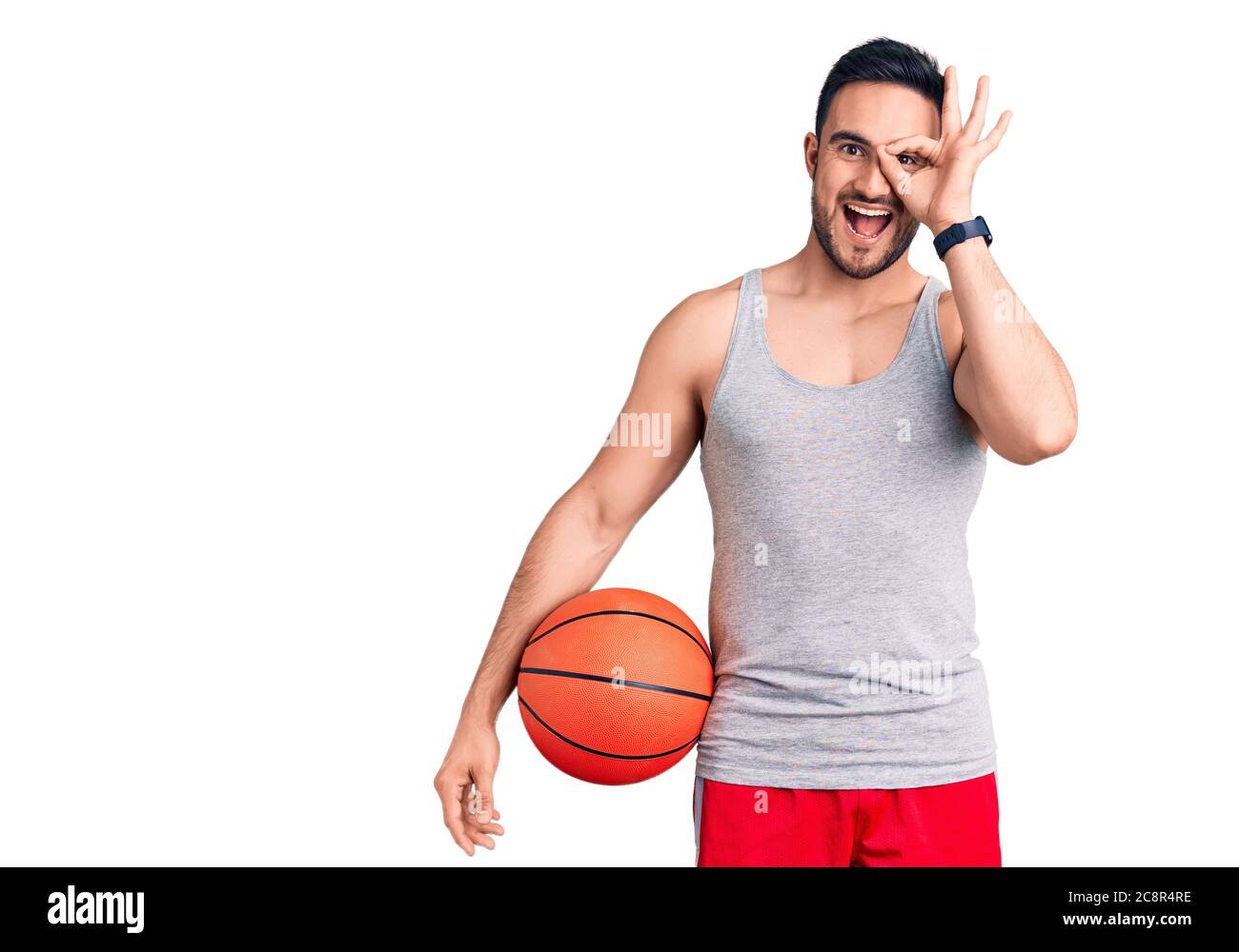 Young handsome man holding basketball ball smiling happy doing ok sign ...