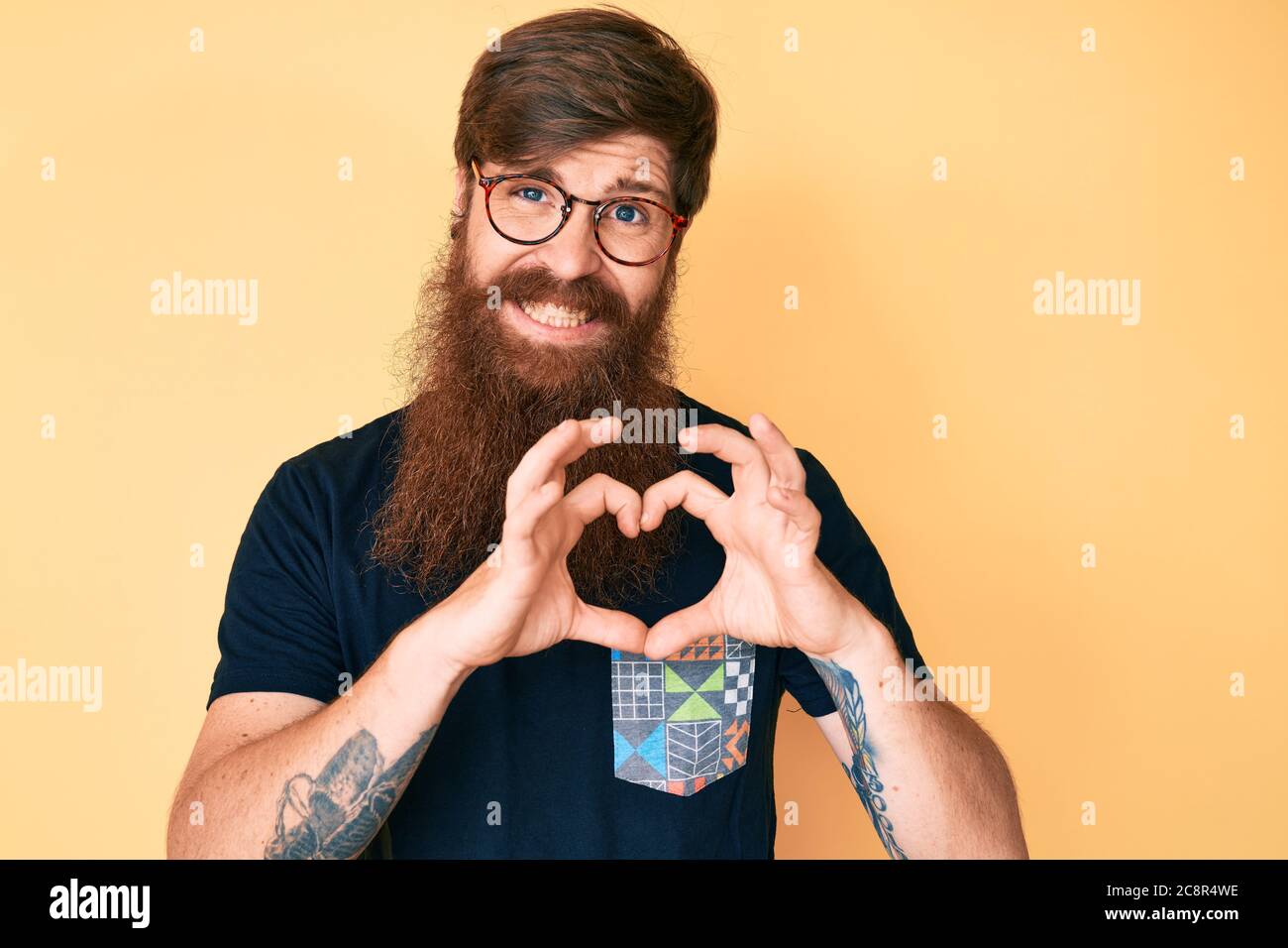 Handsome young red head man with long beard wearing casual clothes and ...
