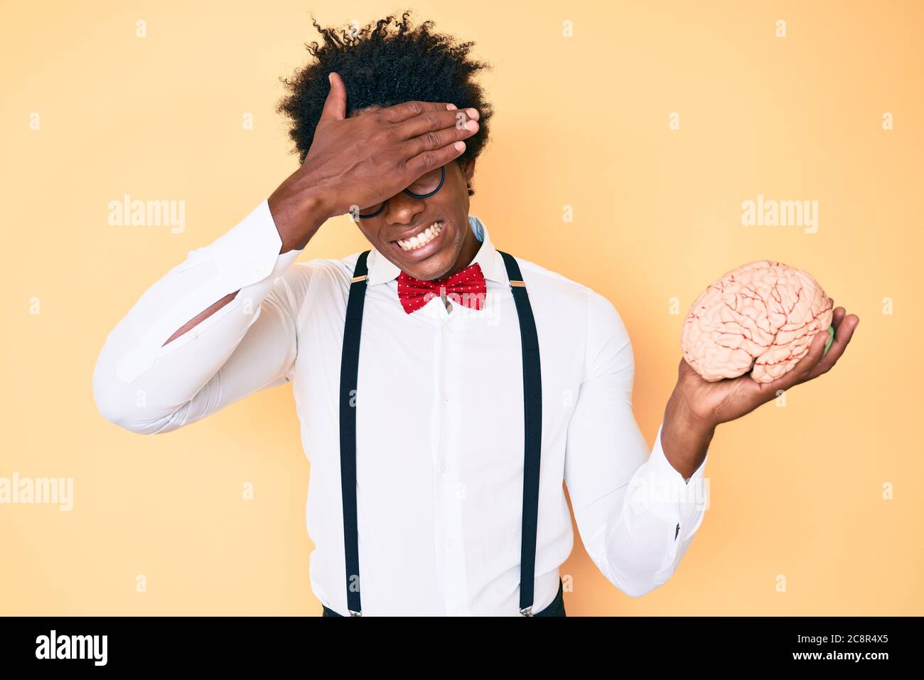 Handsome african american nerd man with afro hair holding brain ...
