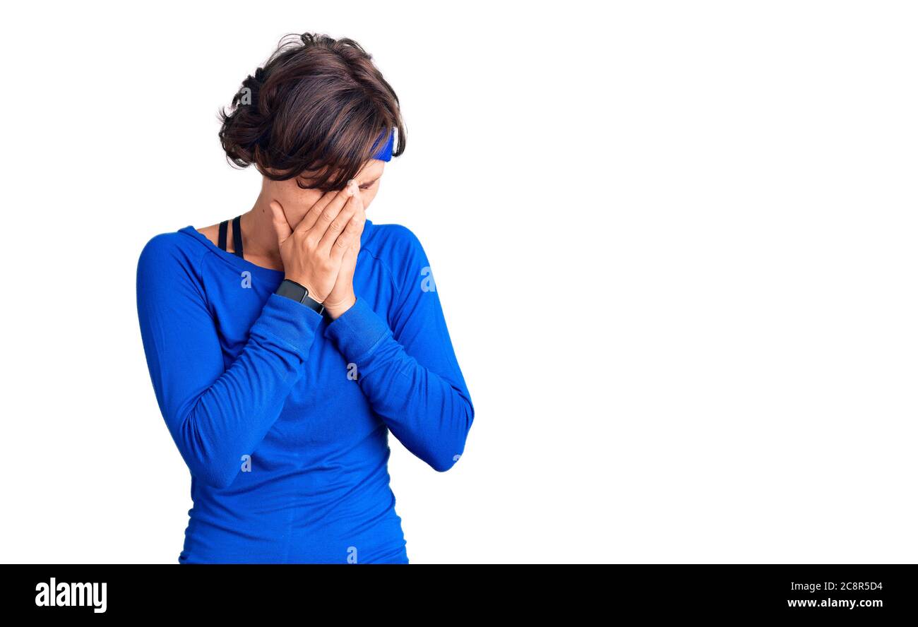 Beautiful young woman with short hair wearing training workout clothes ...