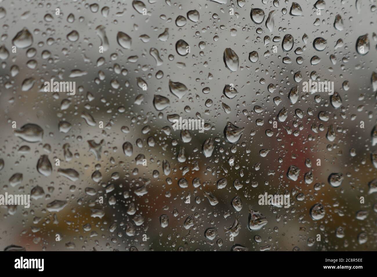 Raindrops on a misted glass with a soft multi-colored background on a ...