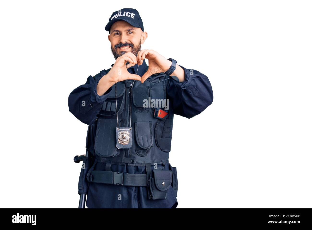 Young handsome man wearing police uniform smiling in love doing heart ...