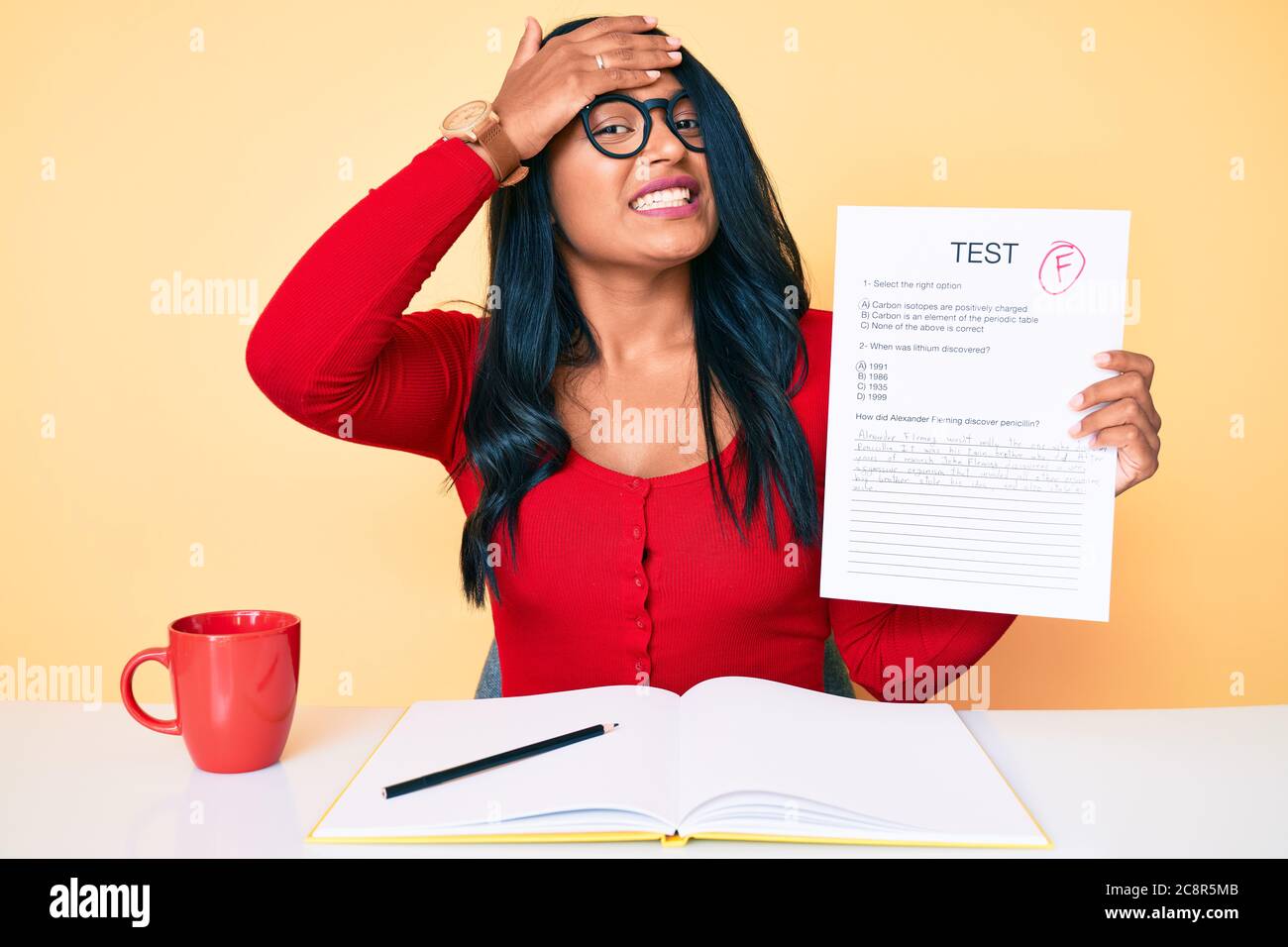 Beautiful latin young woman with long hair showing a failed exam ...