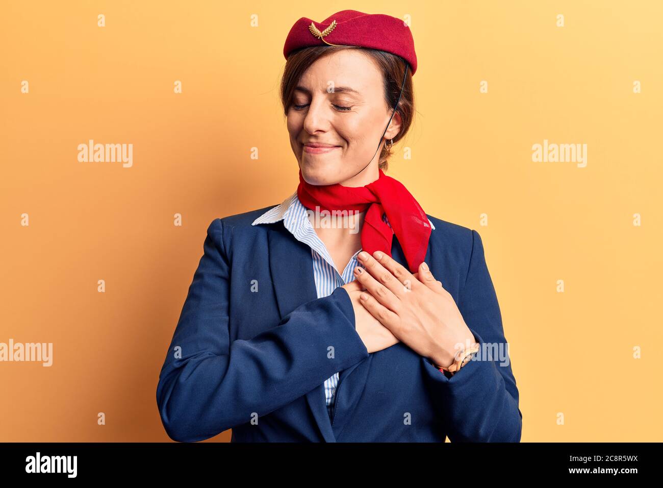 Young beautiful woman wearing stewardess uniform smiling with hands on ...