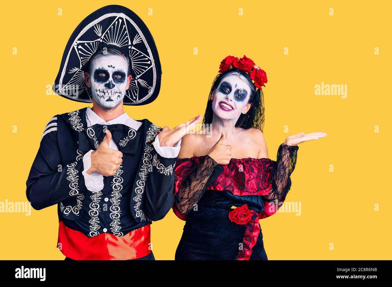Young couple wearing mexican day of the dead costume over background ...