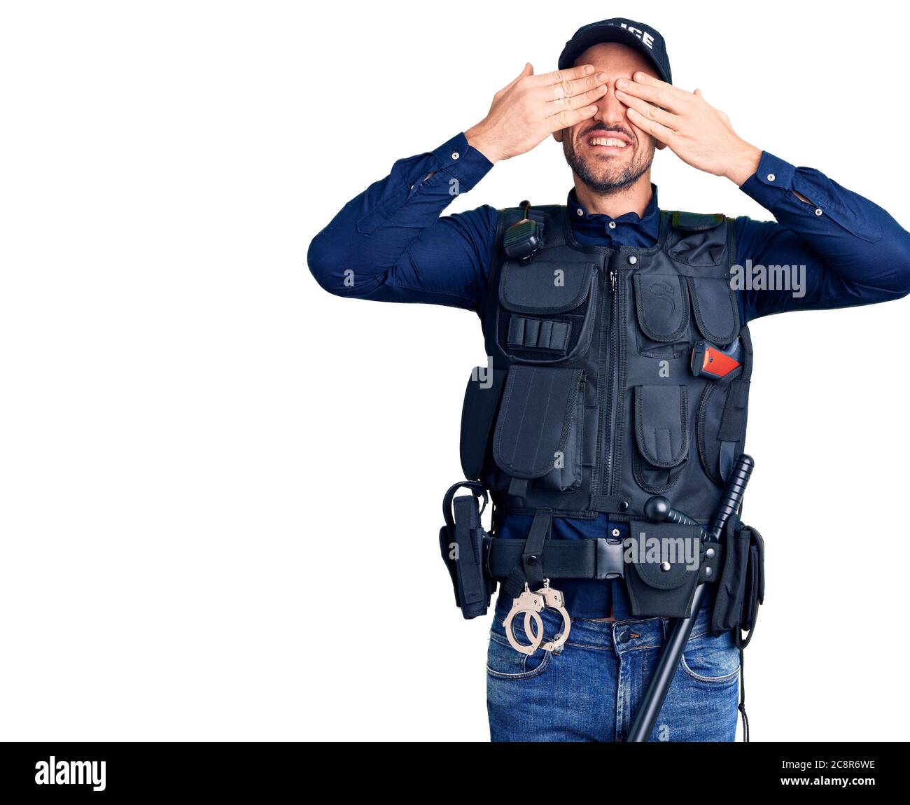 Young handsome man wearing police uniform covering eyes with hands ...