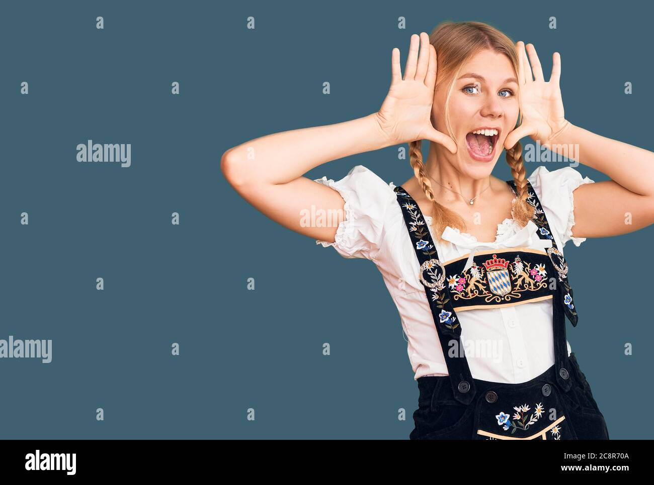 Young beautiful blonde woman wearing oktoberfest dress smiling cheerful ...