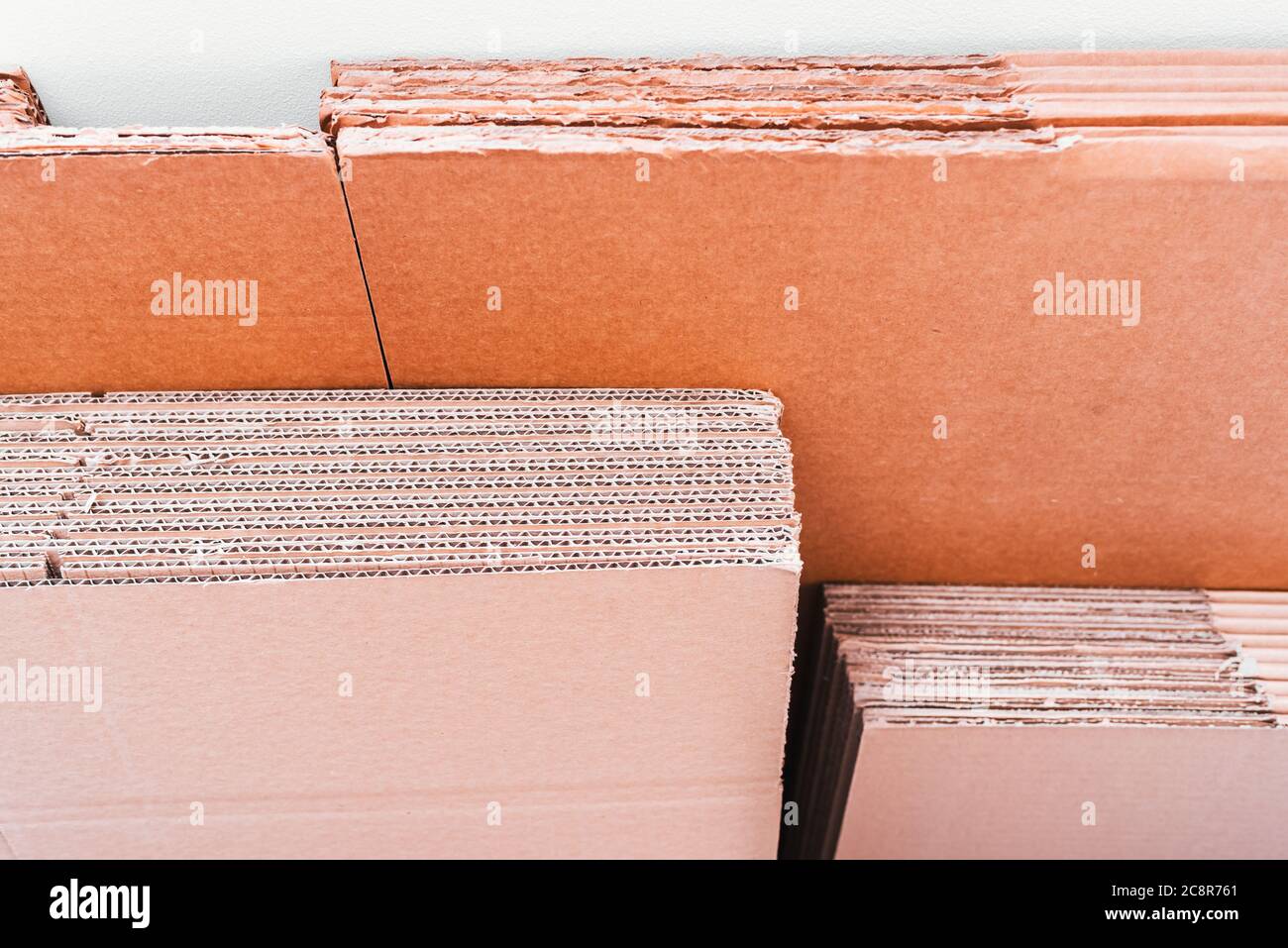 Cardboards stacked on a white wall ready to form boxes to transport ...