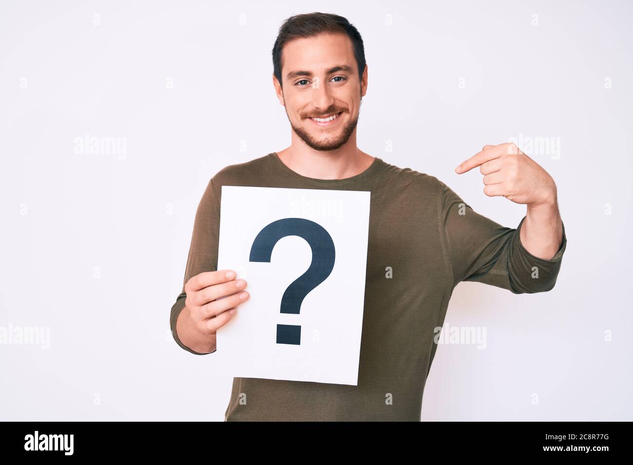 Young handsome man holding question mark pointing finger to one self ...