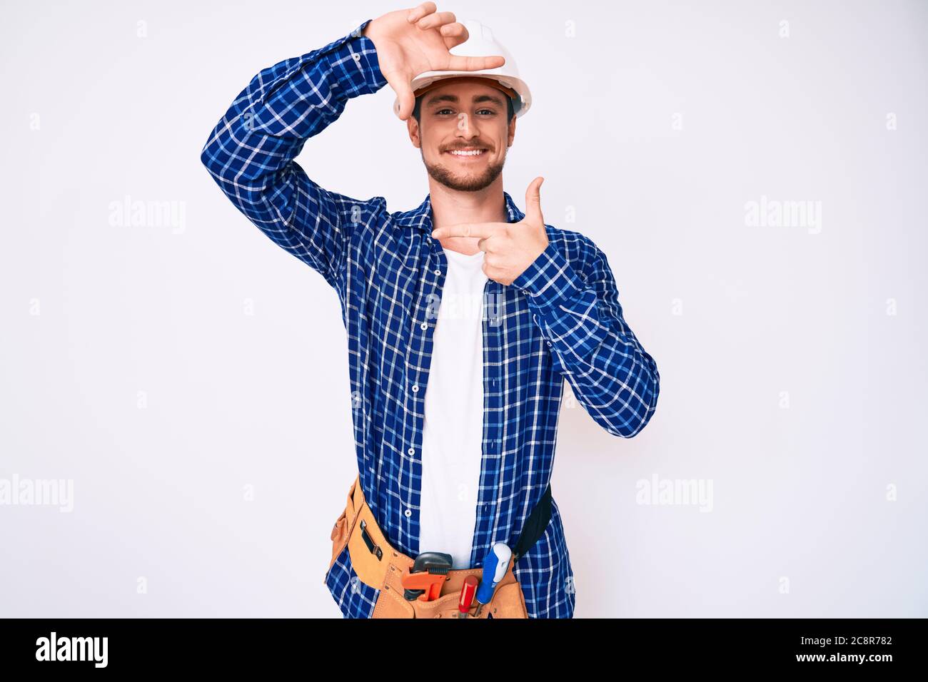 Young handsome man weaing handyman uniform smiling making frame with ...