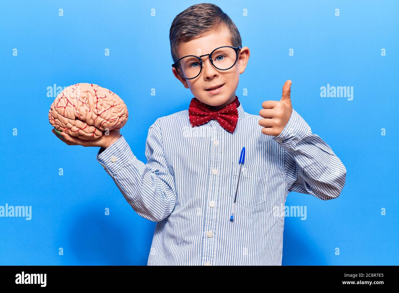 Cute blond kid wearing nerd bow tie and glasses holding brain smiling ...