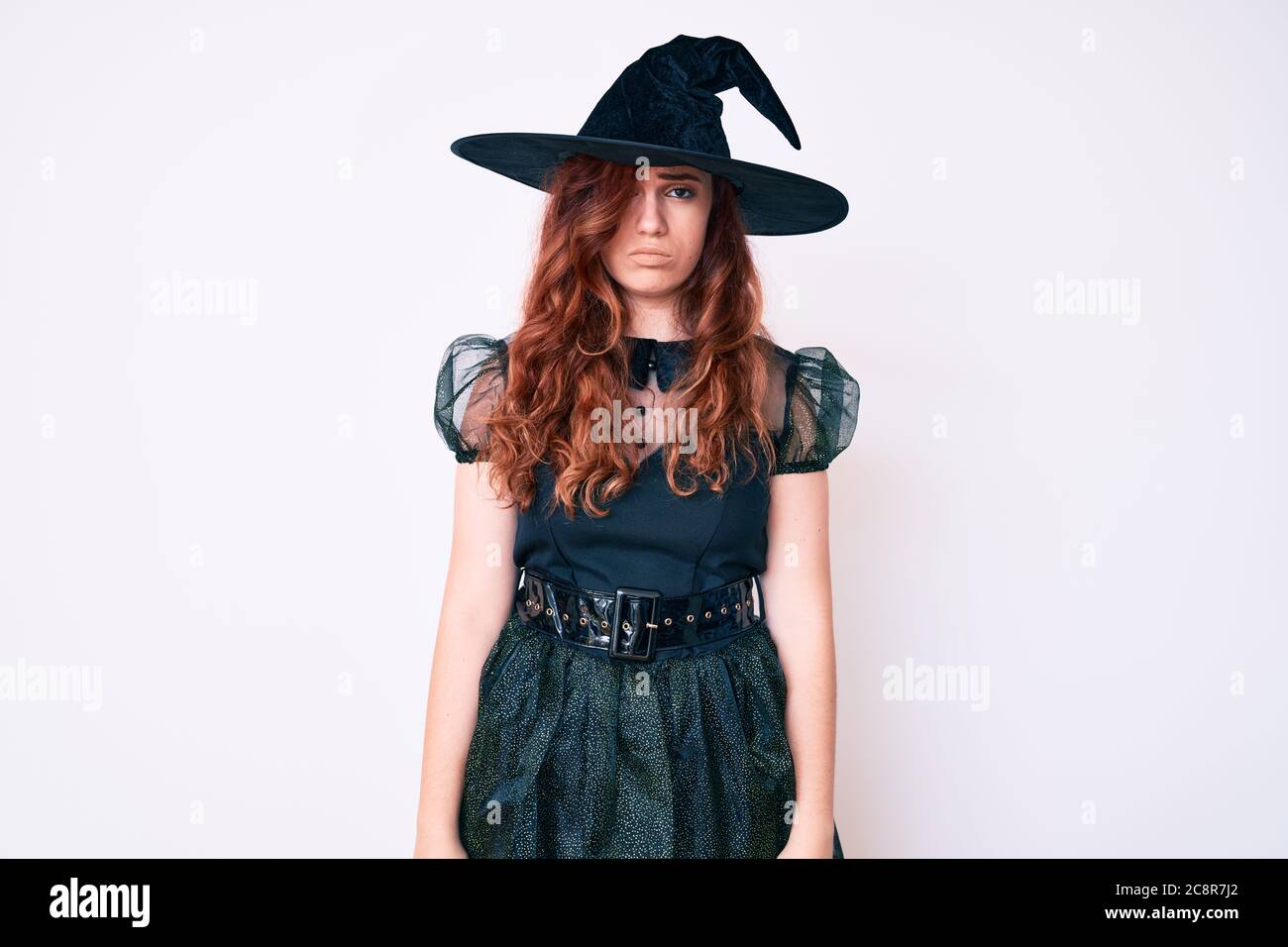 Young beautiful woman wearing witch halloween costume depressed and worry for distress, crying ...