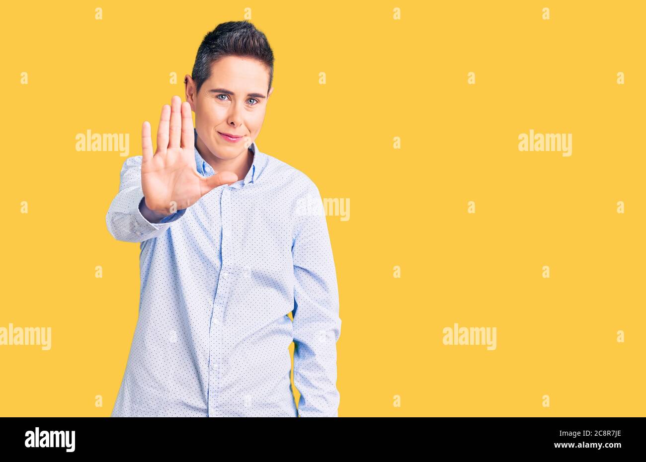 Young woman with short hair wearing business clothes doing stop sing ...