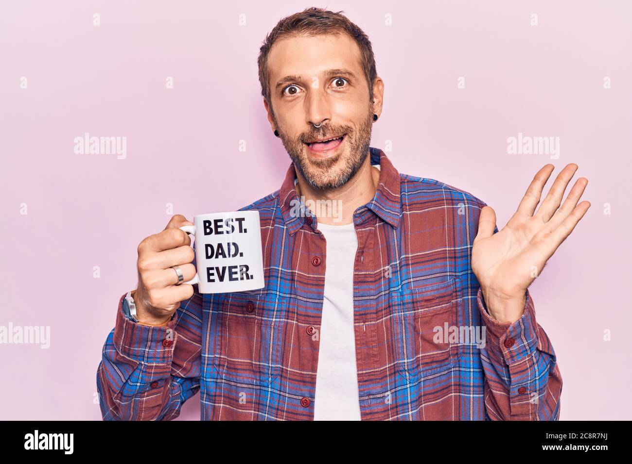 Young handsome man drinking mug of coffe with best dad ever message ...