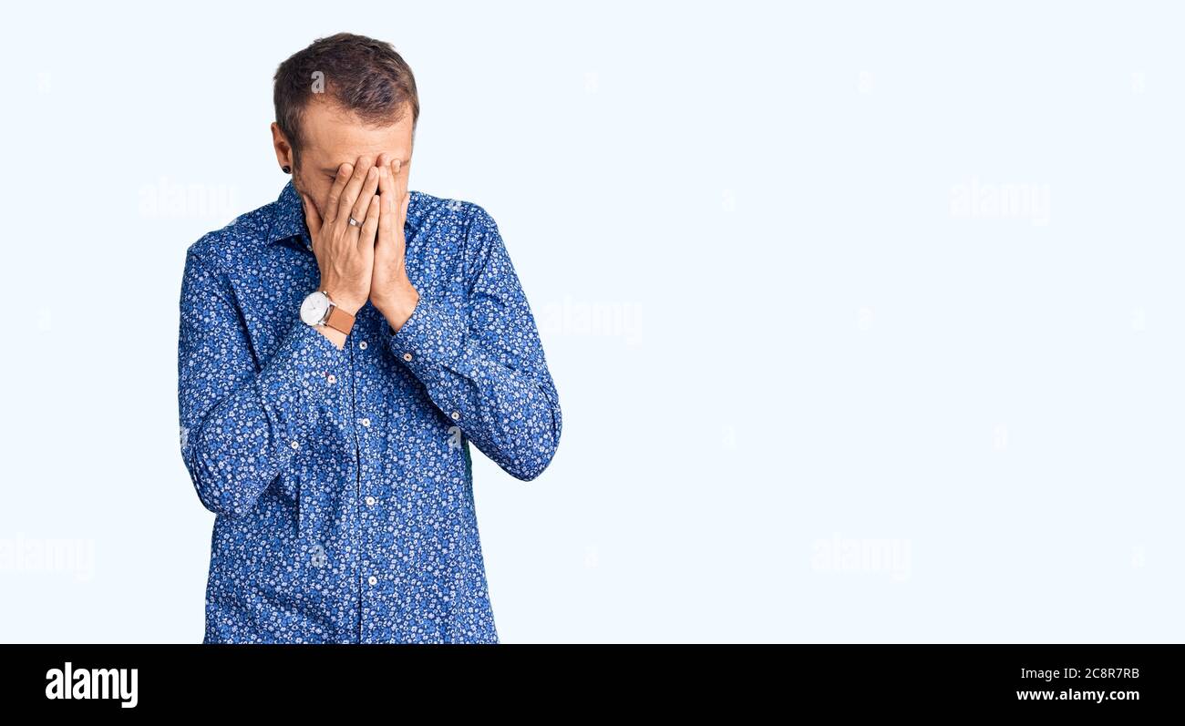 Young handsome man wearing casual clothes with sad expression covering ...