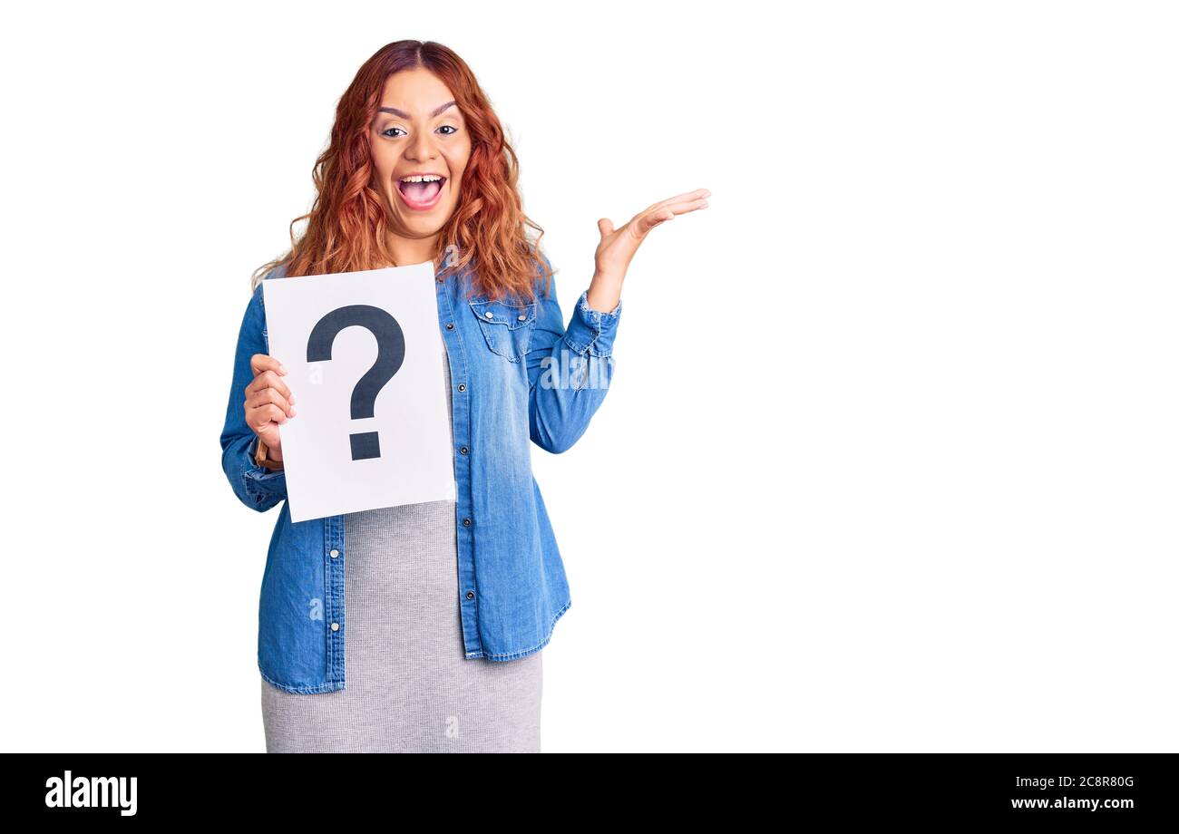 Young latin woman holding question mark celebrating victory with happy ...