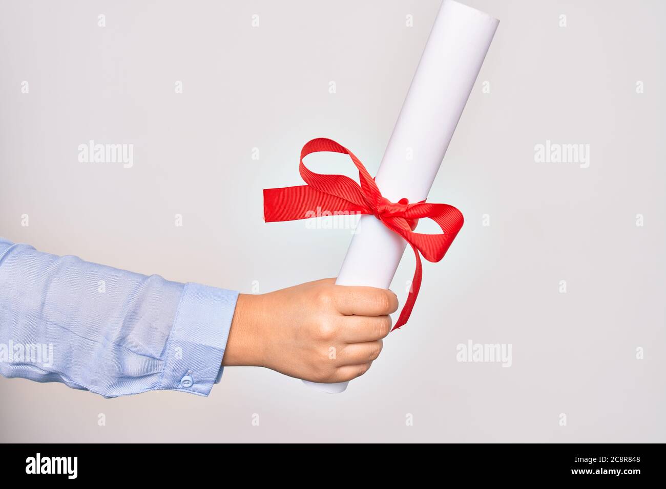 Hand of caucasian young woman holding graduated diploma degree over ...