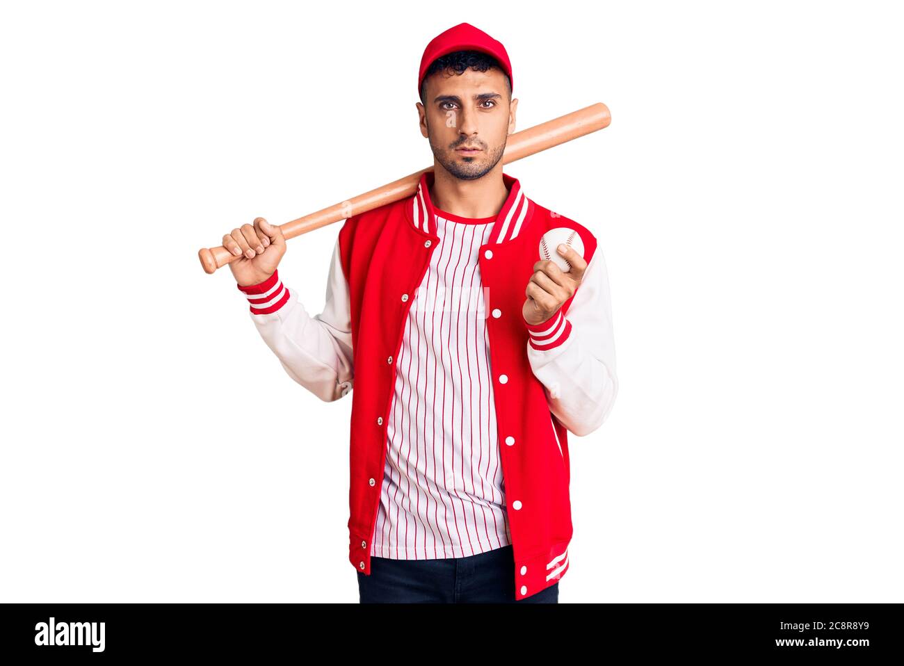 Young hispanic man playing baseball holding bat and ball thinking ...