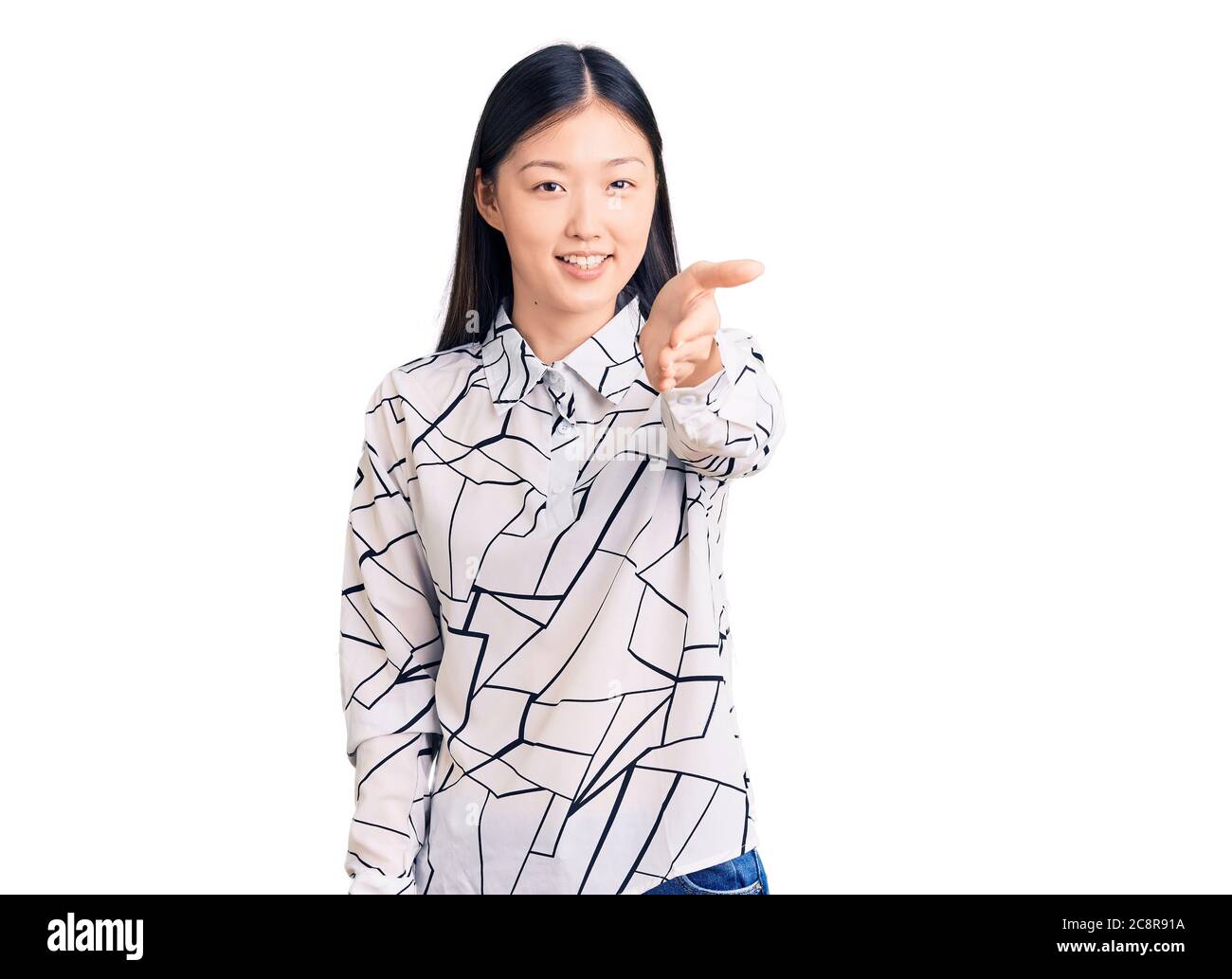 Young beautiful chinese woman wearing casual shirt smiling friendly ...