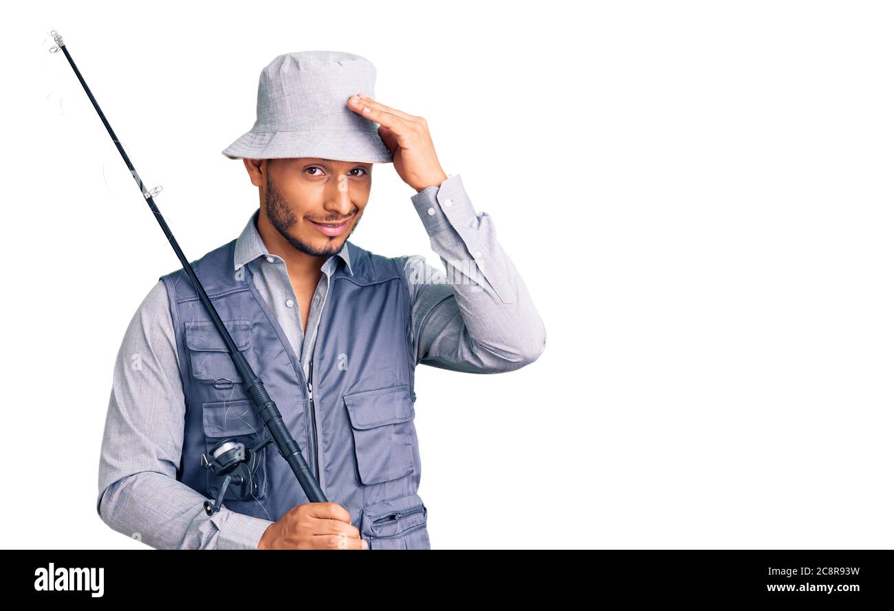 Handsome latin american young man wearing fisherman equipment stressed ...