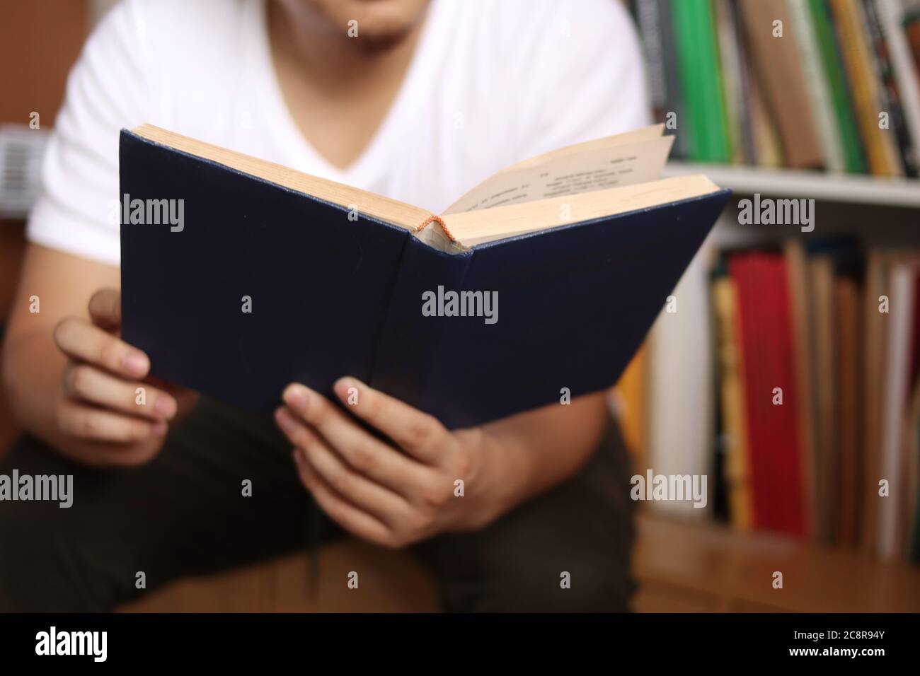 Anonymous man reading book in library, educational concept. Happy ...