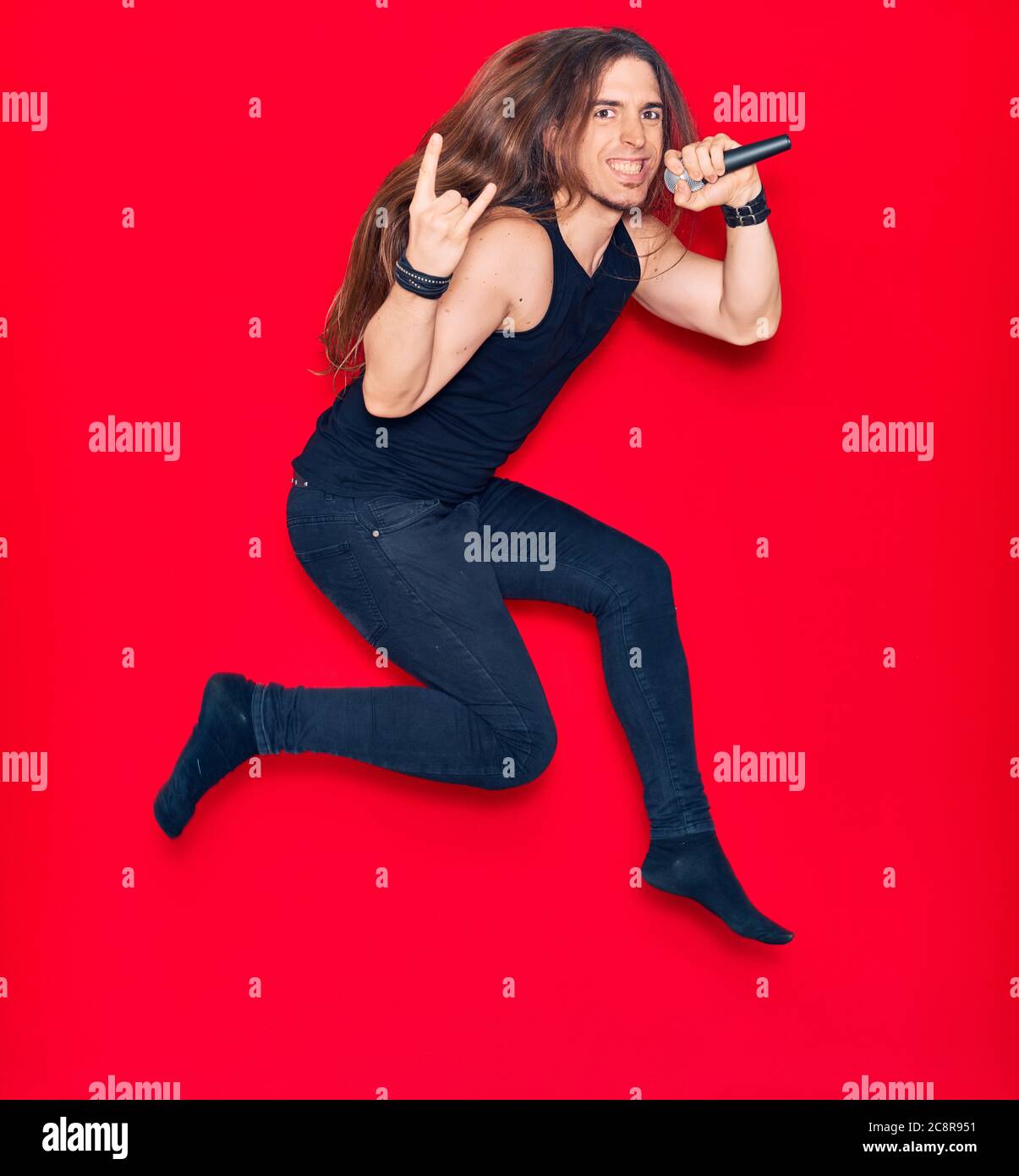 Young handsome heavy metal singer man with long hair and aggressive ...