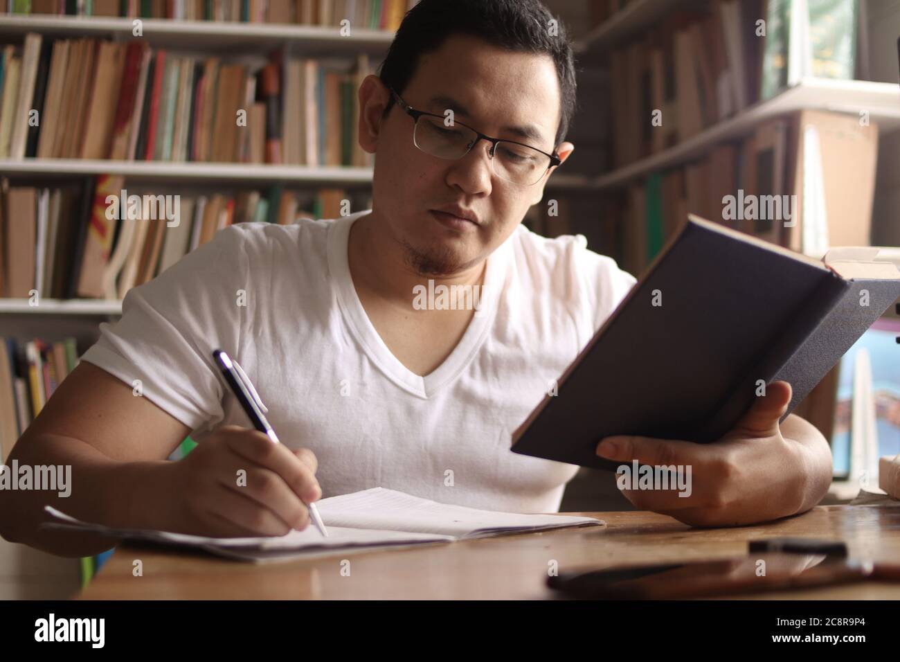 Asian college male writing hi-res stock photography and images - Alamy