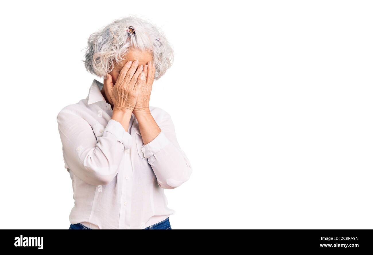 Senior grey-haired woman wearing casual clothes with sad expression ...