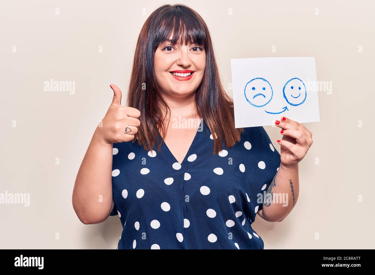 Young plus size woman holding sad to happy emotion paper smiling happy ...