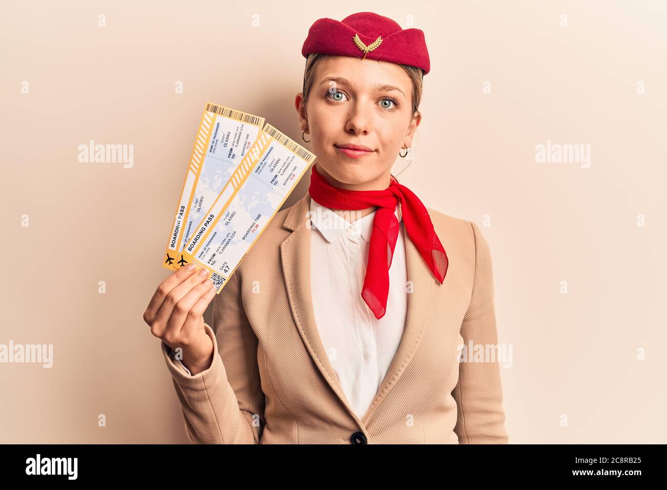 Young beautiful blonde girl wearing stewardess uniform holding boarding ...