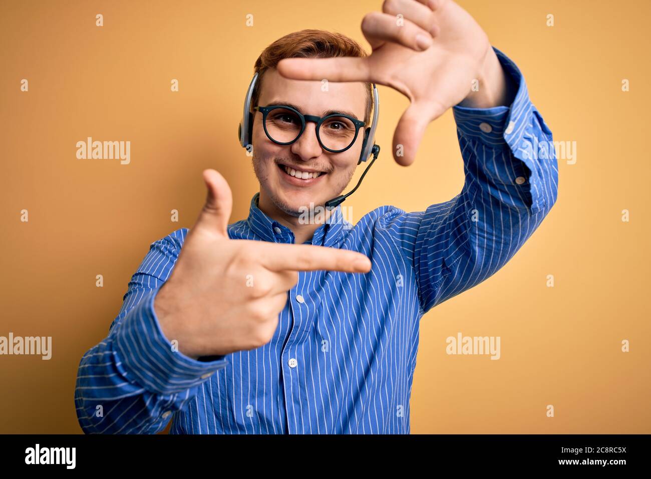 Young handsome redhead call center agent man wearing glasses working ...
