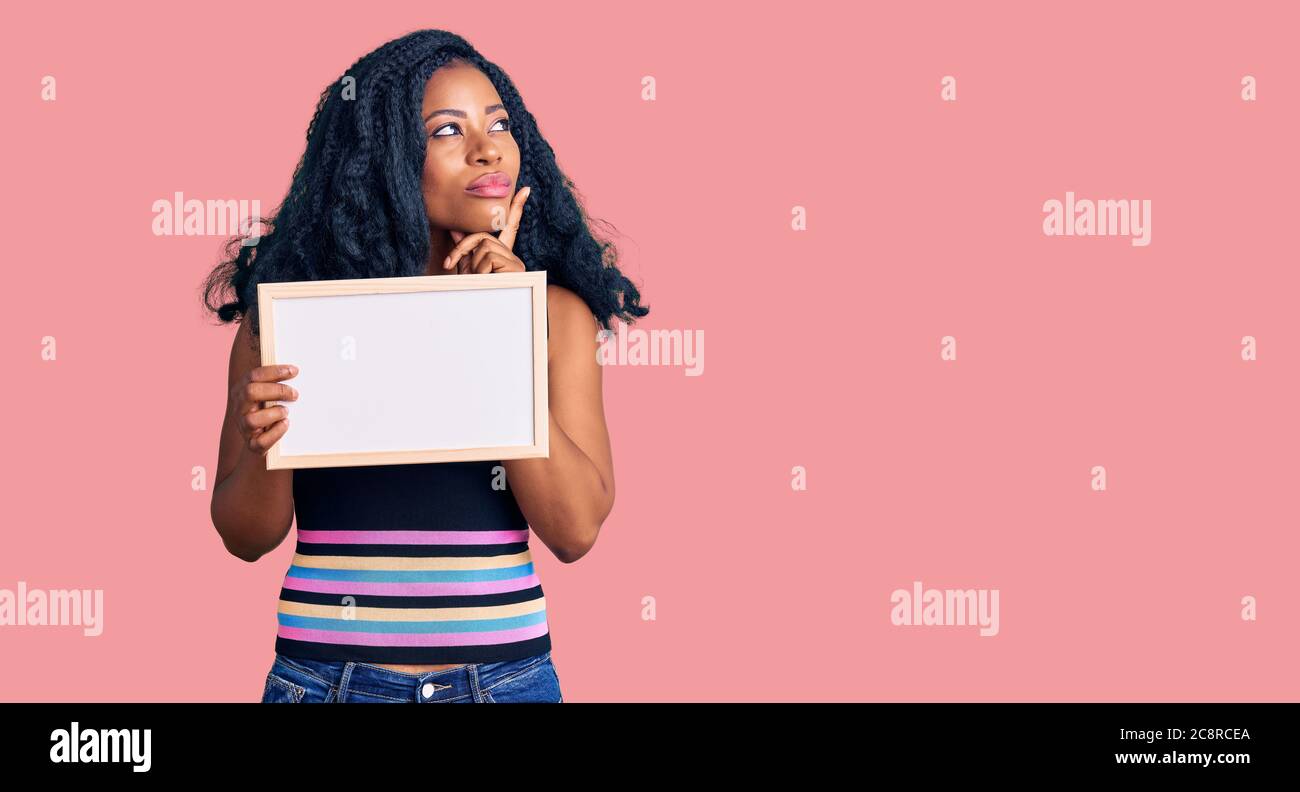 Beautiful african american woman holding blank empty banner serious ...