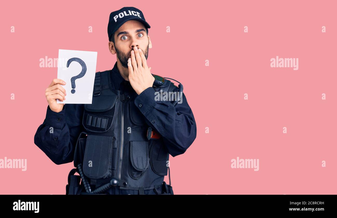 Young handsome man with beard wearing police uniform holding question ...