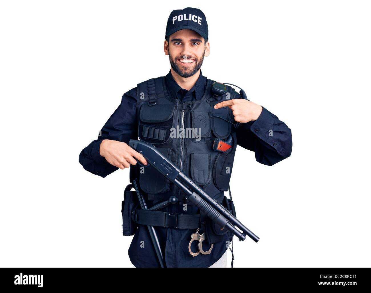 Young handsome man with beard wearing police uniform holding shotgun ...