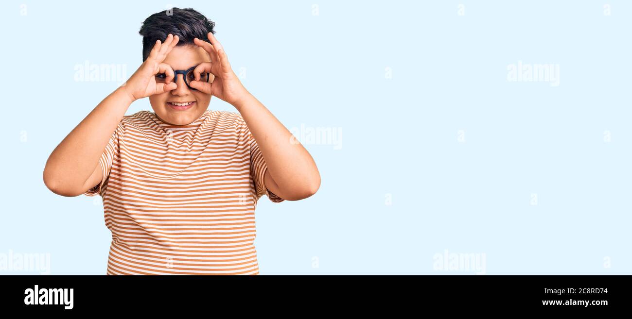 Little boy kid wearing casual clothes and glasses doing ok gesture like ...