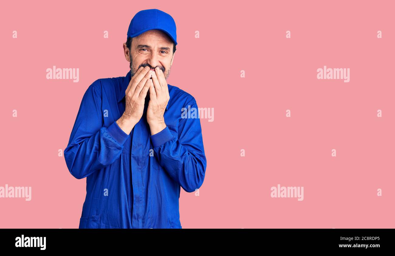 Middle age handsome man wearing mechanic uniform laughing and ...