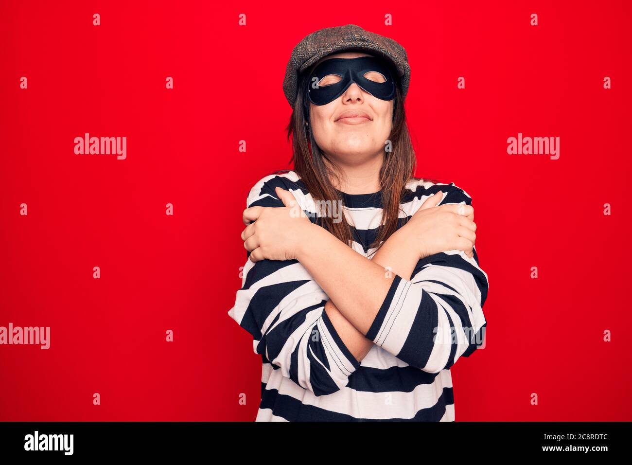 Young beautiful brunette burglar woman wearing cap and mask over ...