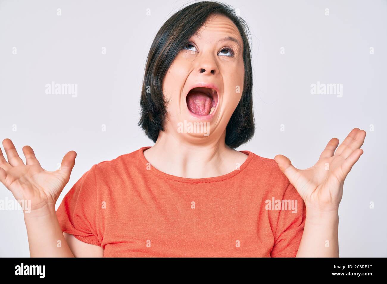 Brunette woman with down syndrome wearing casual clothes crazy and mad ...