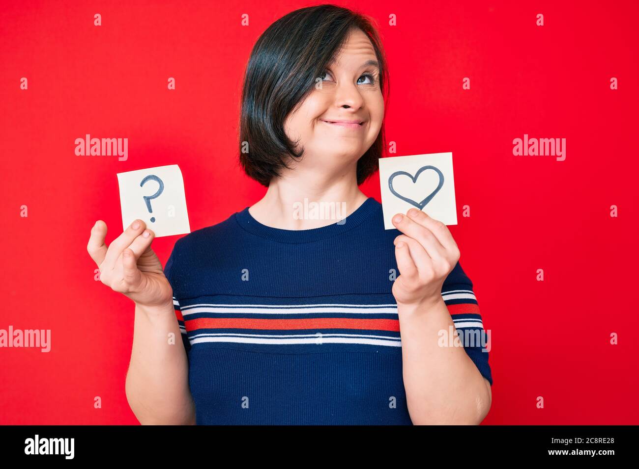 Brunette woman with down syndrome holding heart and question mark ...