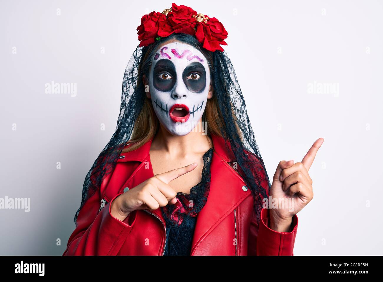 Woman wearing day of the dead costume pointing with fingers to the side ...