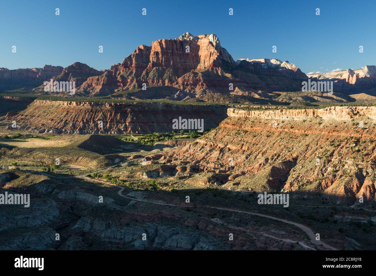 Sun sets over the Zion National Park skyline with its many red rock ...