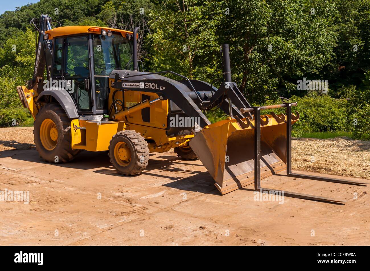 Heavy construction equipment idle along a road on a sunny summer day ...