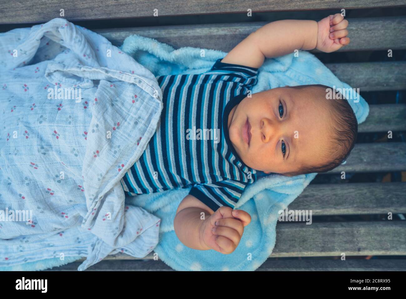 A little baby is resting on a bench Stock Photo - Alamy